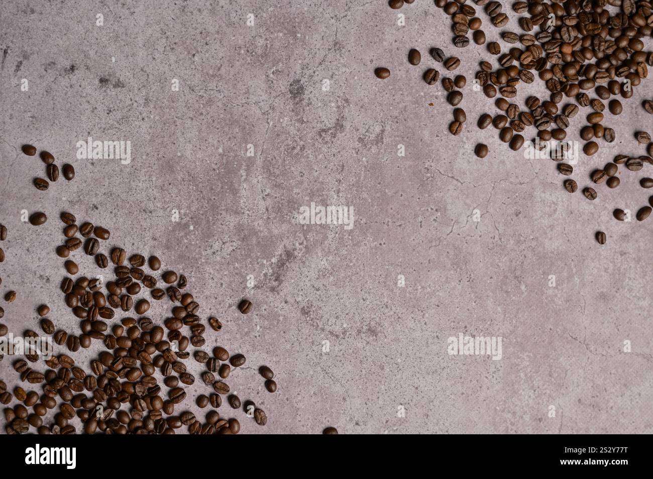 Top view roasted coffee beans in the two corners on gray concrete. Copy ...