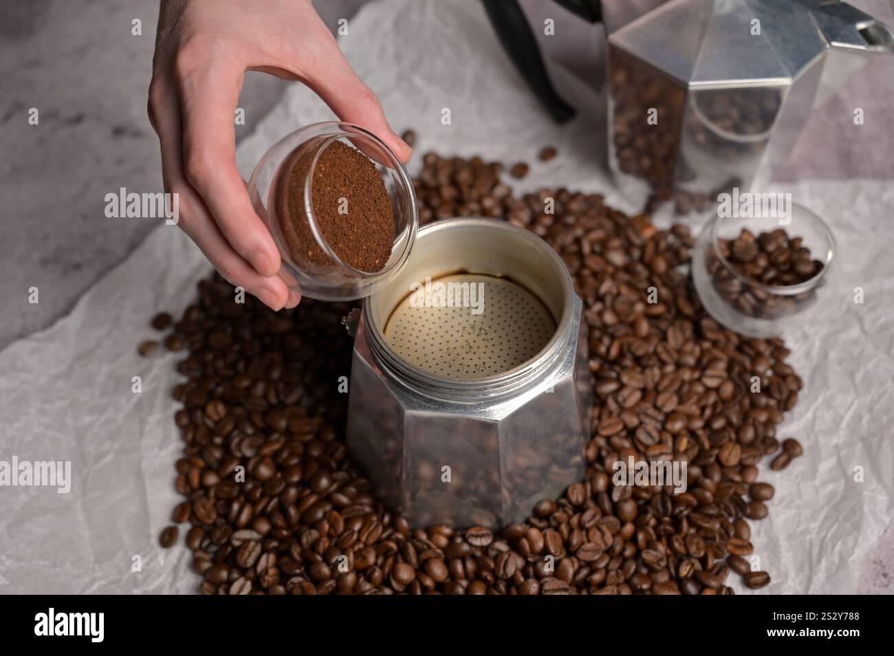 Woman's hands pouring coffee from a small transparent cup in geyser ...