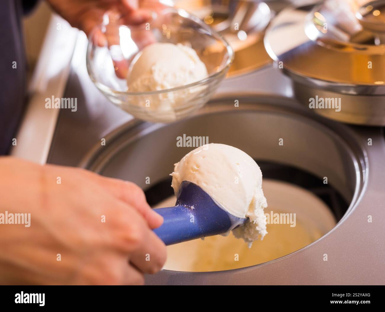 Scoop of creamy ice cream in spoon from the refrigerator container ...