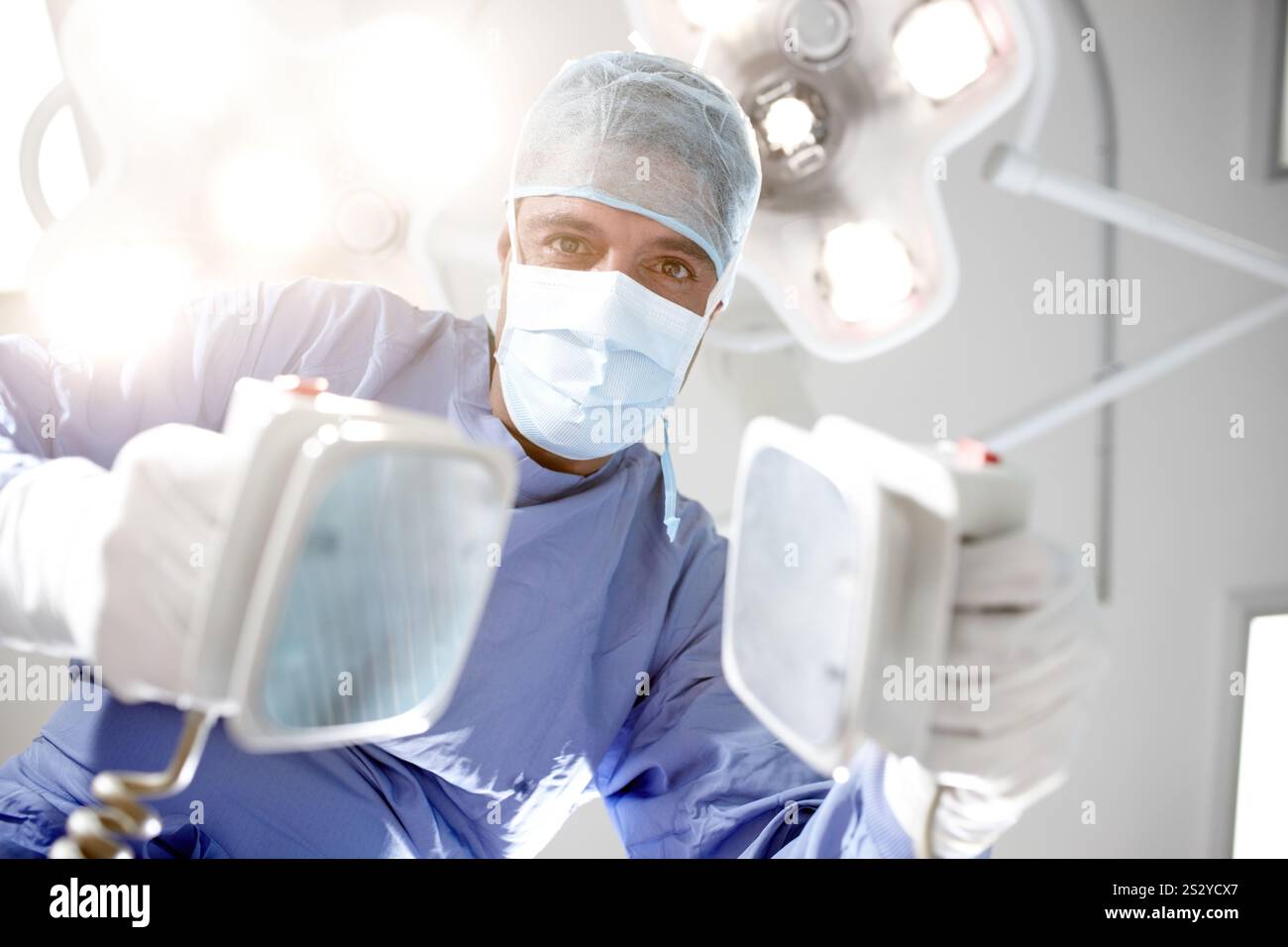 Surgeon, defibrillator and machine in surgery in theatre of cardiology ...