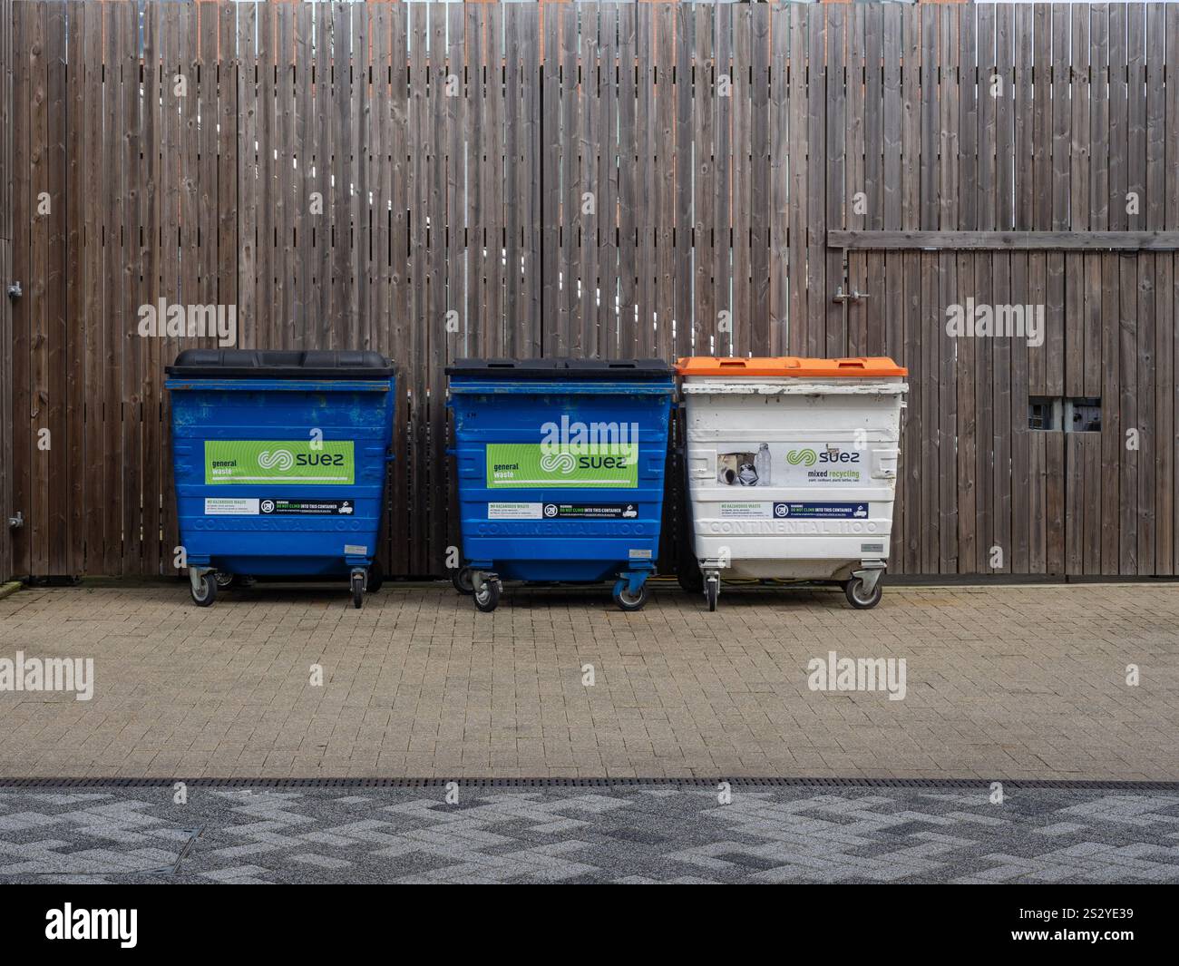 Three large wheeled recycling bins supplied by Suez Waste, against ...
