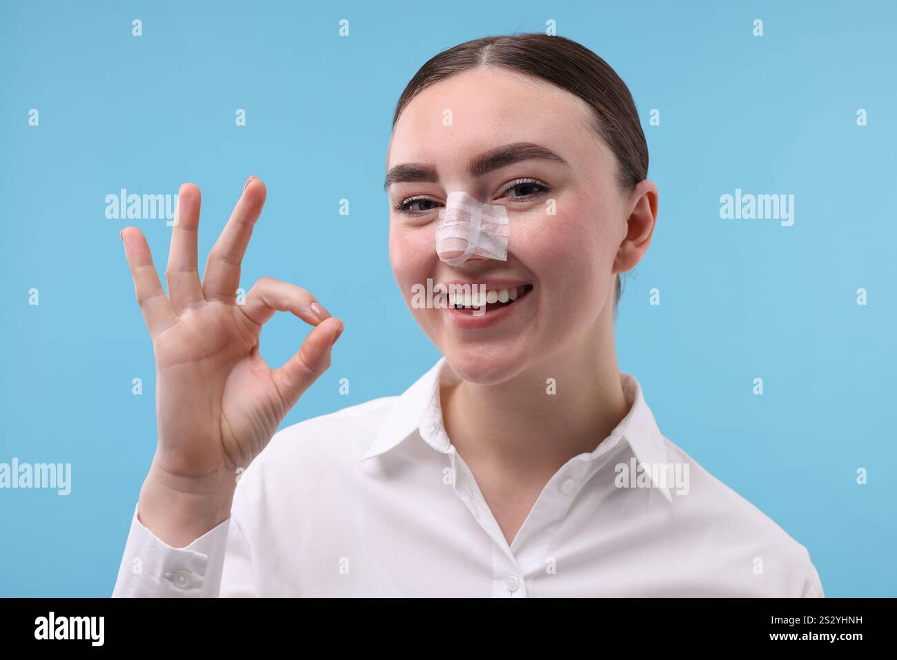 Woman with medical bandage on her nose after plastic surgery operation ...