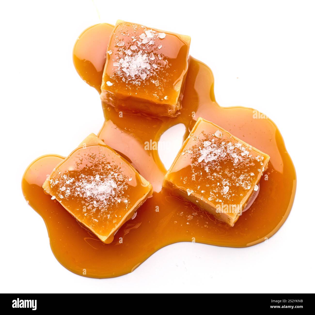 salted caramel candy in melted caramel sauce isolated on white ...