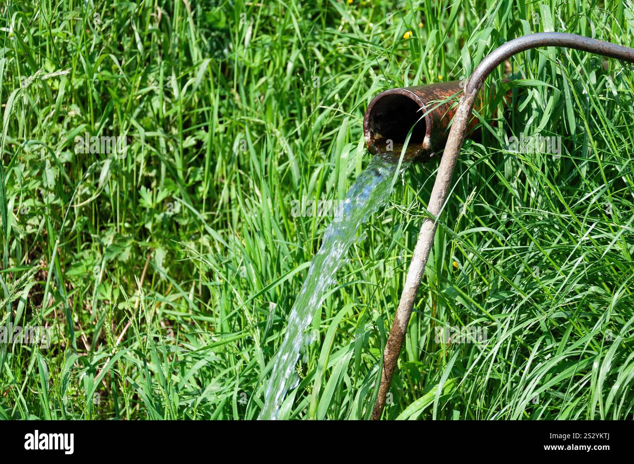 Fresh Water Emerging from a Metal Pipe on Green Grass Background Stock ...