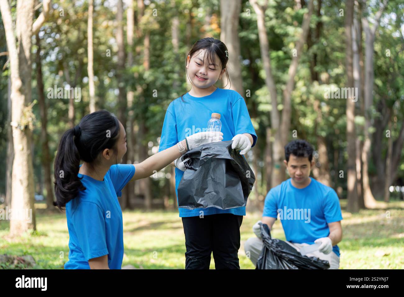 Community volunteer family participates in garbage collection event at ...