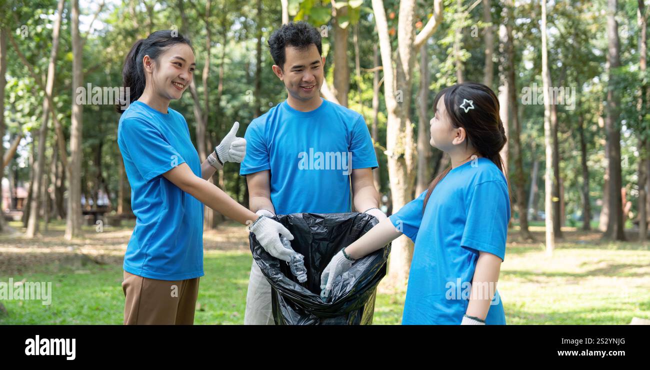 Volunteer family engaging in garbage collection at park outdoor ...