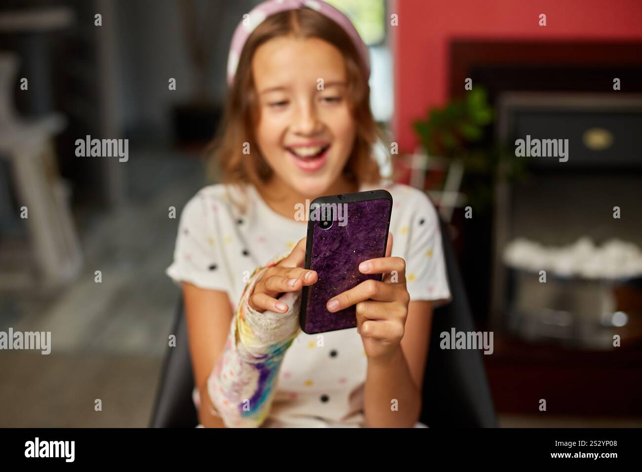 Teen girl with a broken arm orthopedic cast use smartphone, play or ...