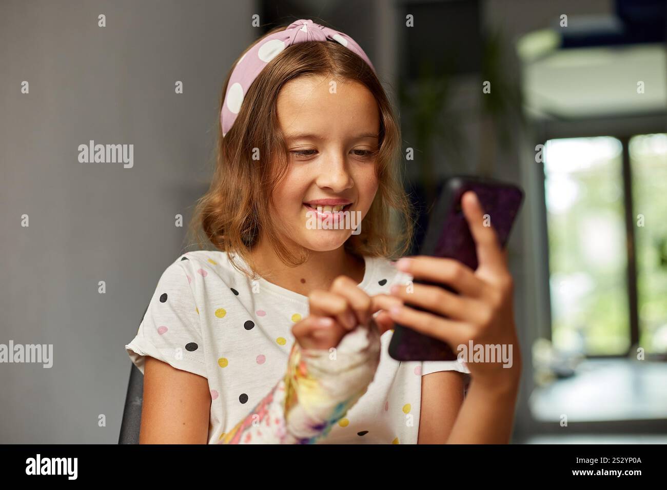 Teen girl with a broken arm orthopedic cast use smartphone, play or ...