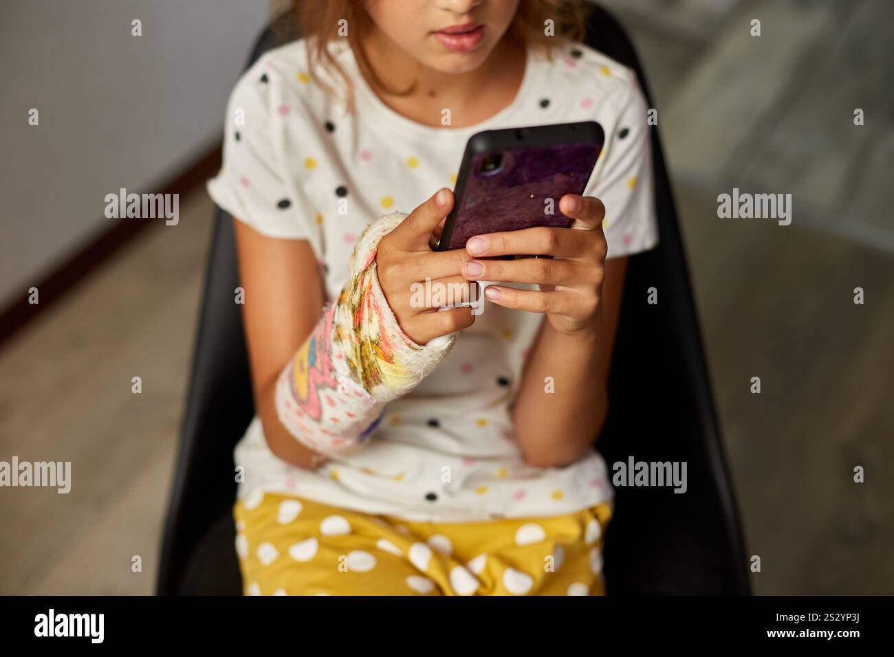 Teen girl with a broken arm orthopedic cast use smartphone, play or ...