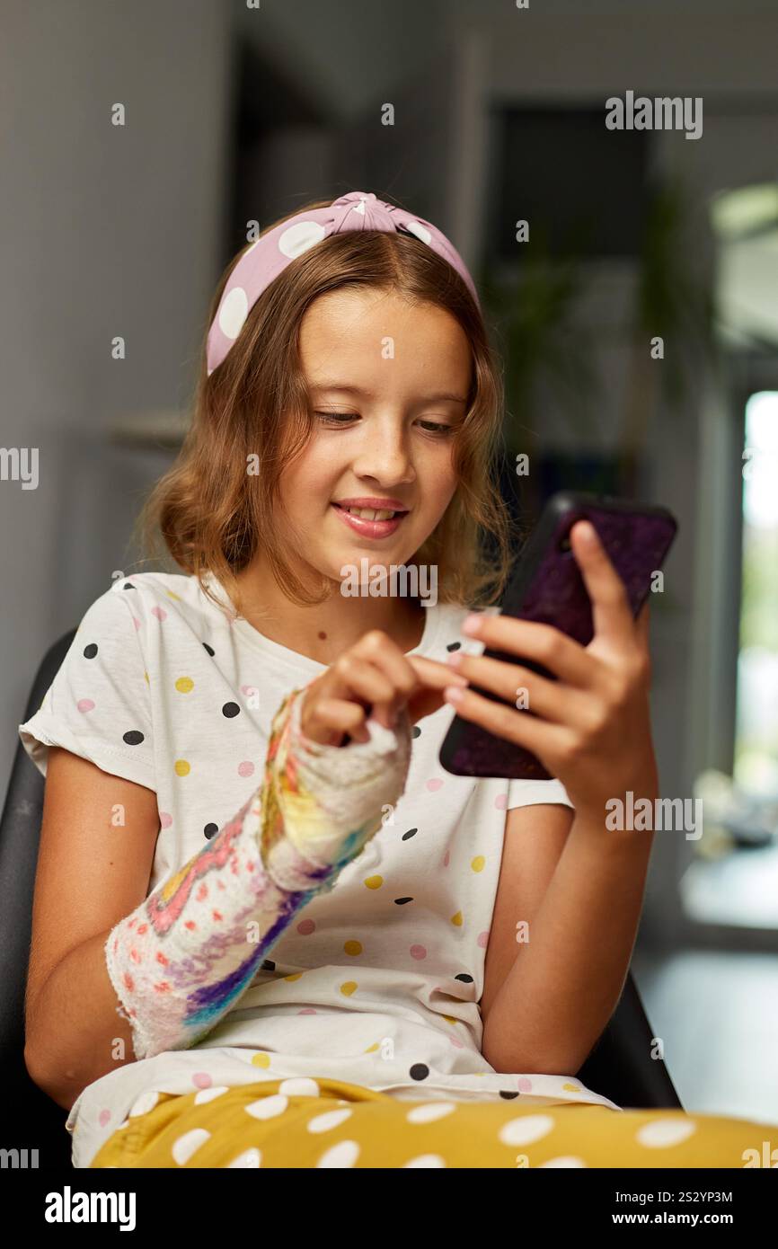 Teen girl with a broken arm orthopedic cast use smartphone, play or talking video call Stock ...