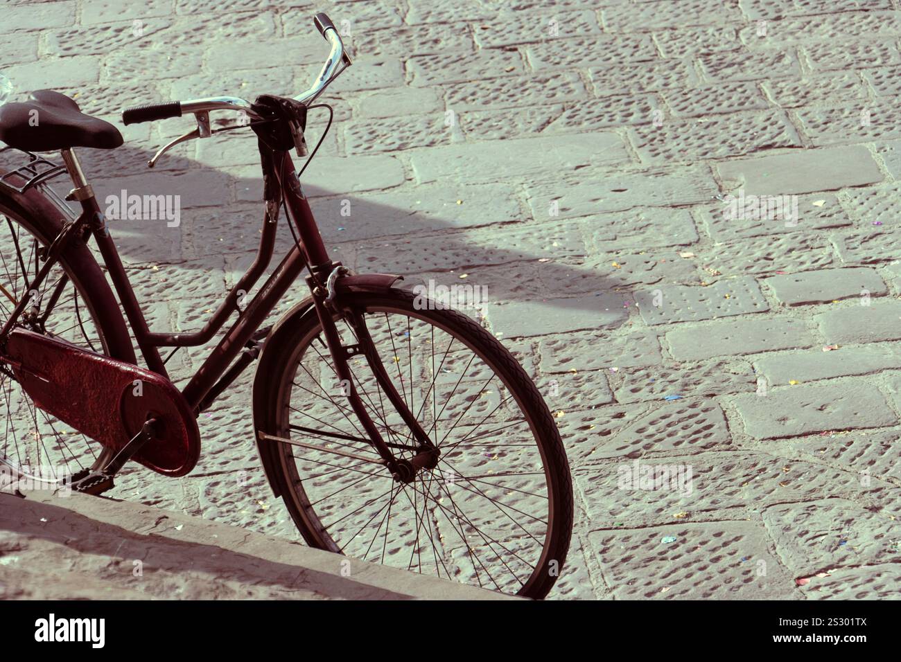 Rusty antique bicycle in a cobblestone square in Florence. The ground ...