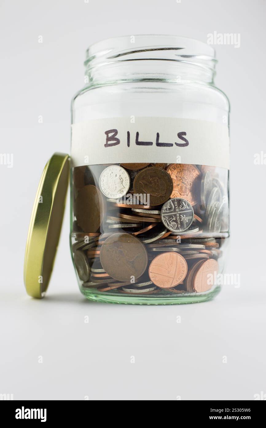 A glass jar containing coins with a handwritten label indicating money ...