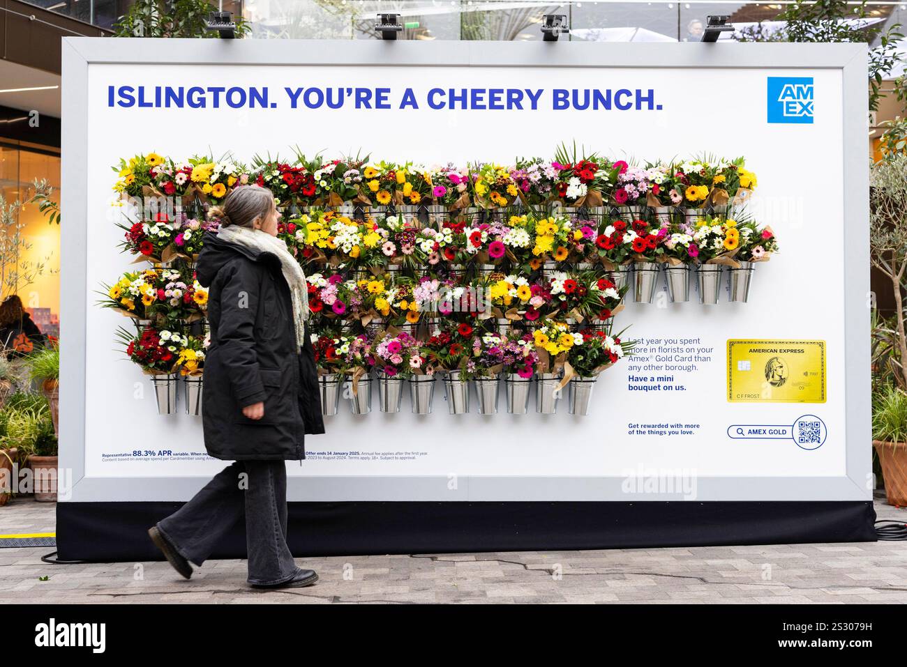 EDITORIAL USE ONLY A passerby in Islington chooses a free bouquet of ...