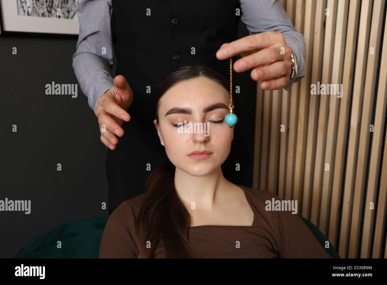 Psychologist using pendulum while working with patient during hypnosis ...