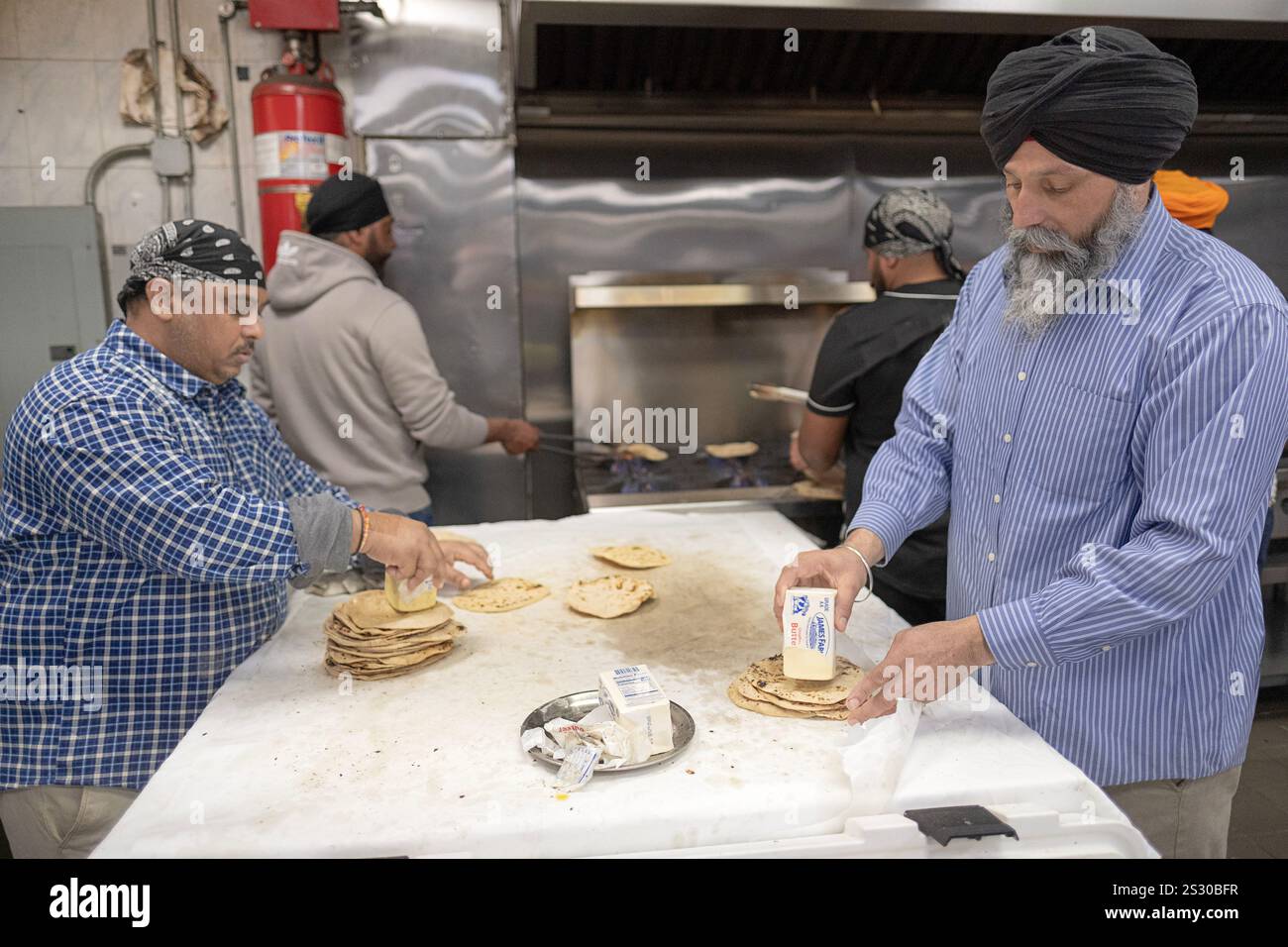 At the end of the process of preparing roti breads, Sikh men toast and ...