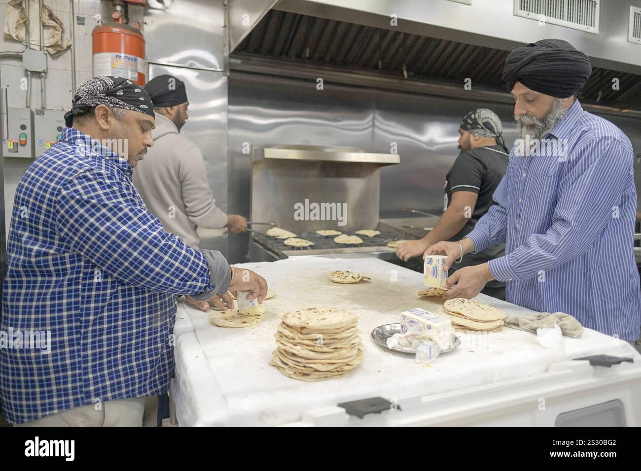 At the end of the process of preparing roti breads, Sikh men toast and ...