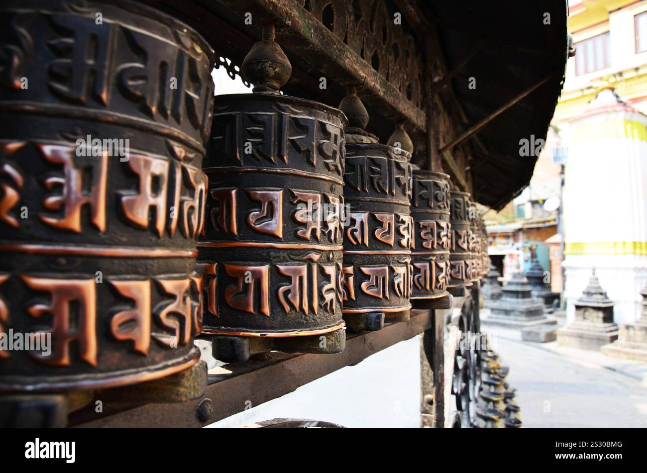 Prayer wheels or mani holy wheel and mantra written tibetan on wall ...