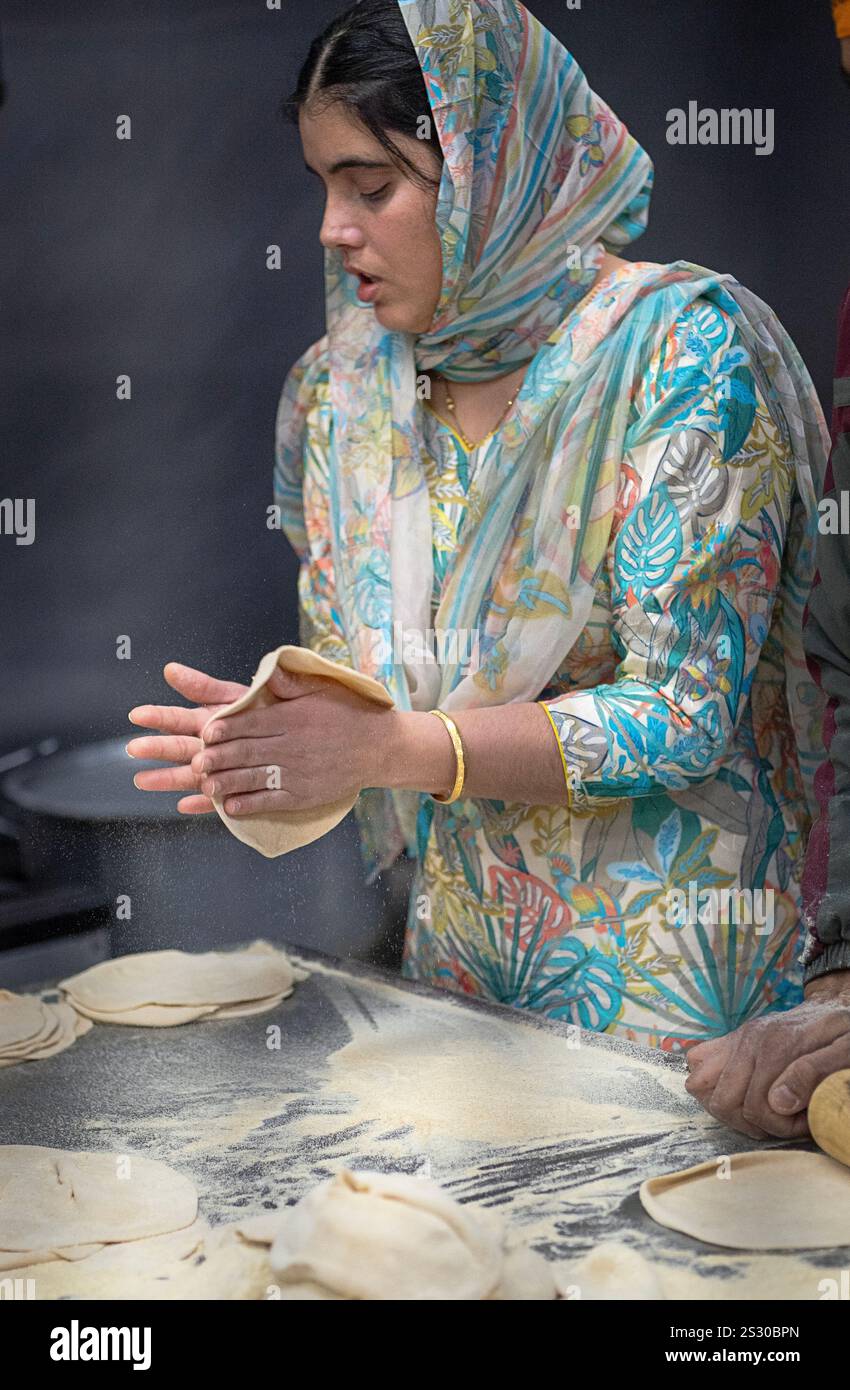 An attractive young Sikh woman volunteering in her local temple ...
