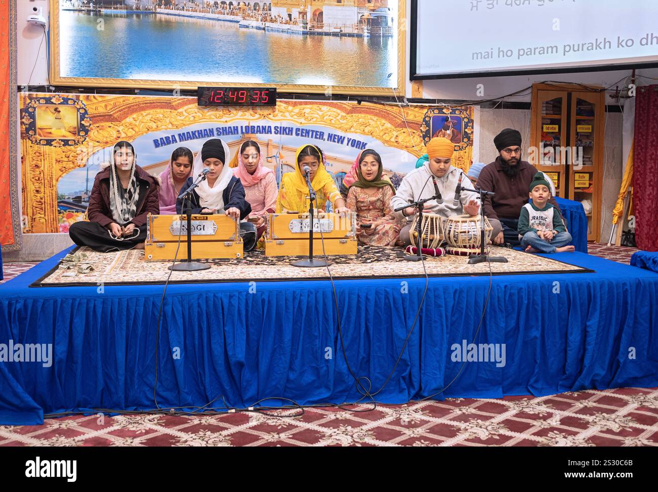 Sikh teenagers play instruments and sing during services in the mani ...