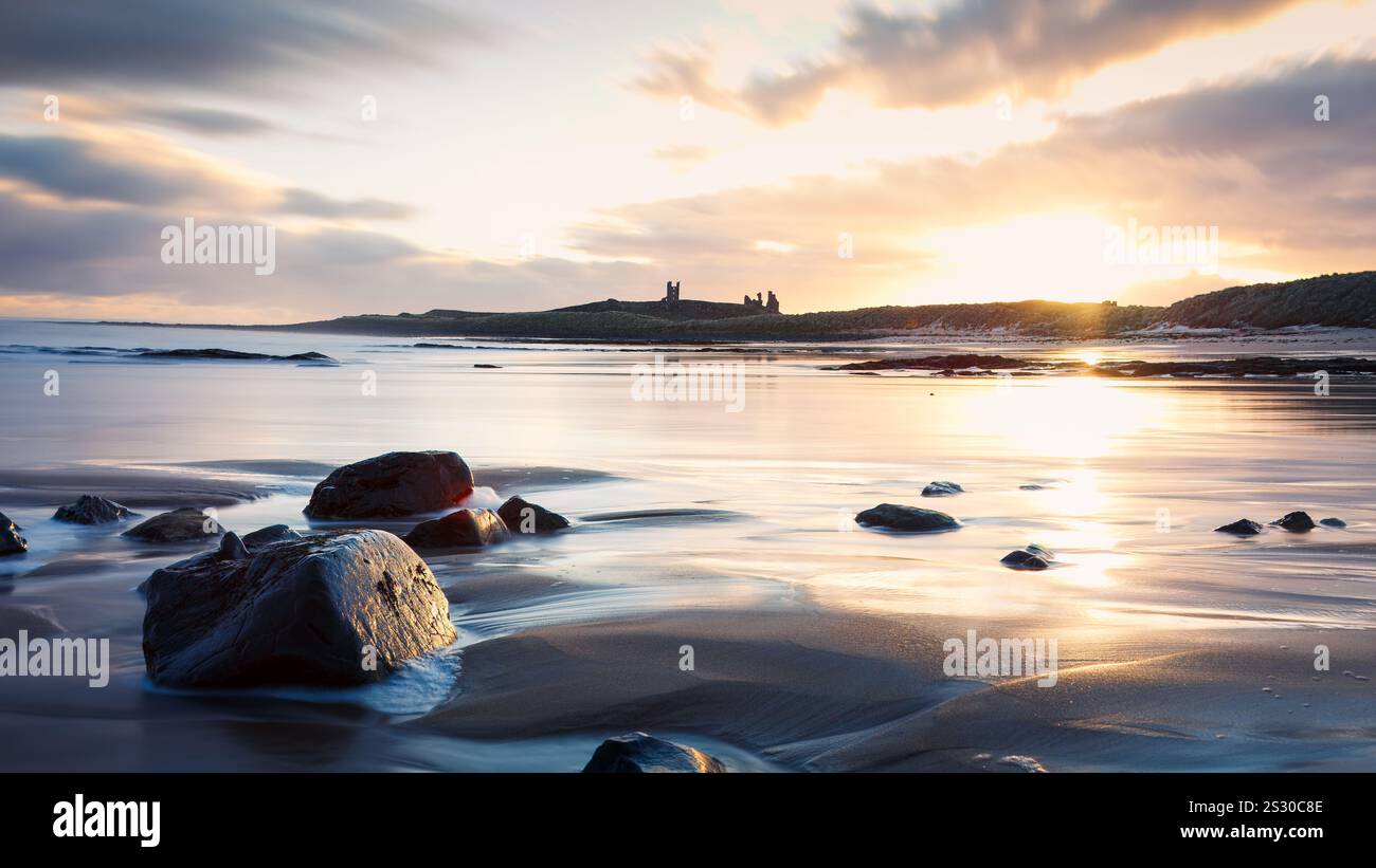 Sunrise over Dunstanburgh Castle, on Embleton Bay Stock Photo - Alamy
