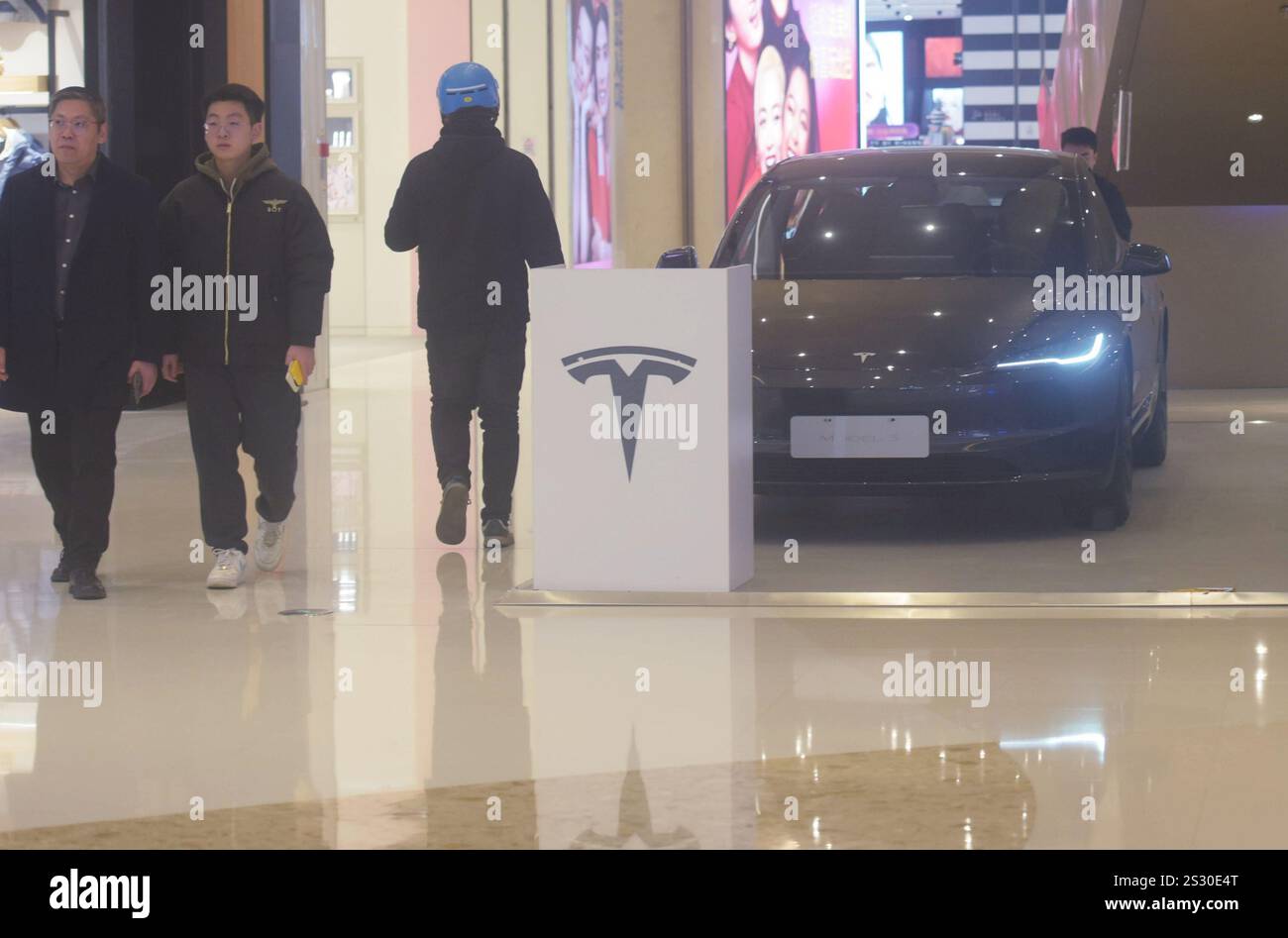 HANGZHOU, CHINA - JANUARY 8, 2025 - Customers walk past a Tesla outlet ...