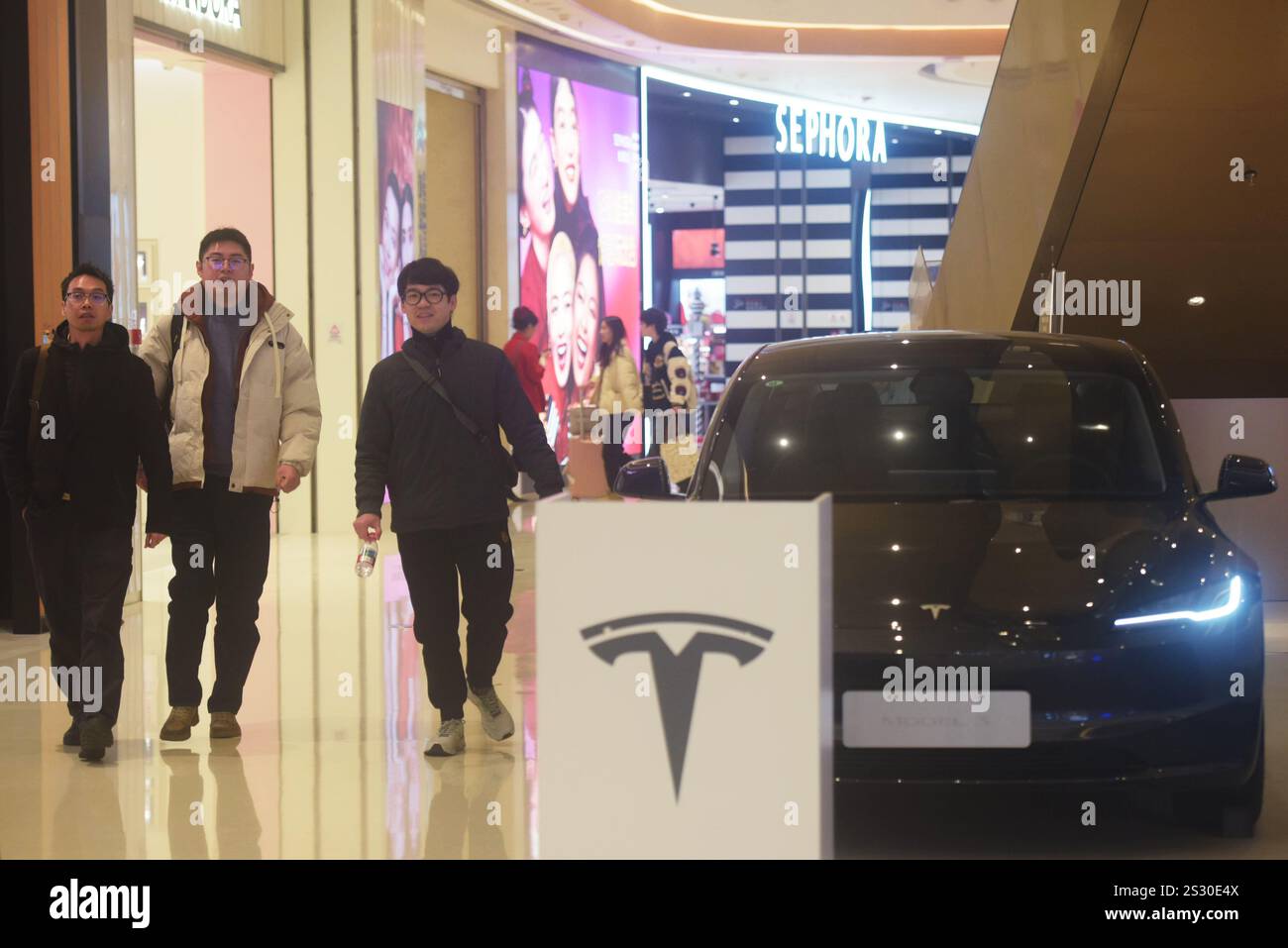 HANGZHOU, CHINA - JANUARY 8, 2025 - Customers walk past a Tesla outlet ...