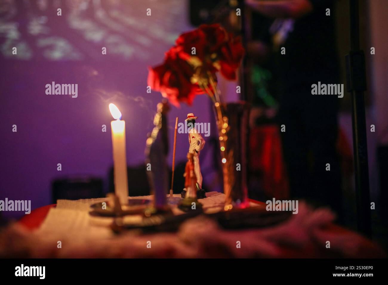 An altar featuring Umbanda deities, a candle and flowers is installed ...