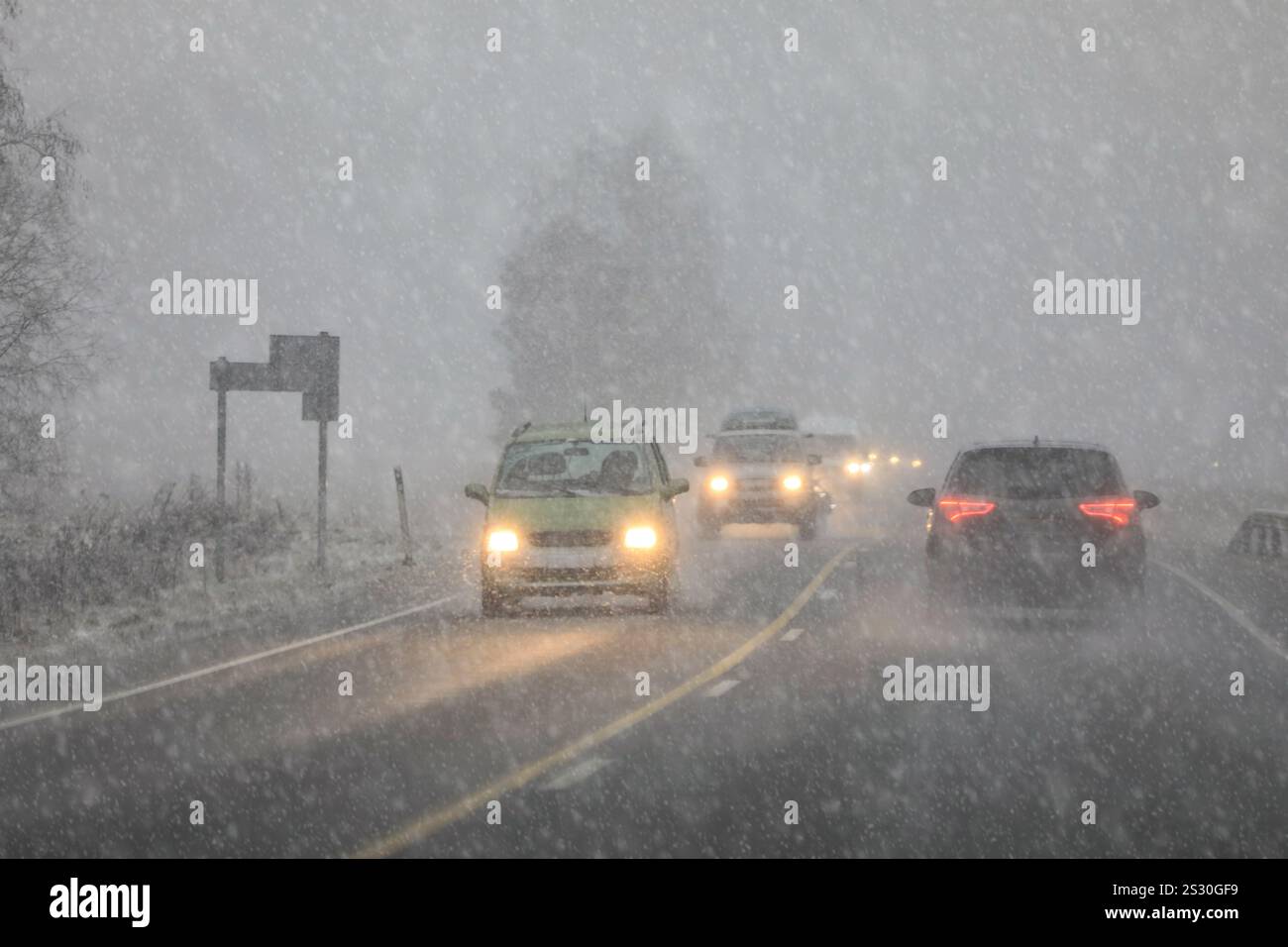 Driving in highway traffic with winter sleet and snow creating low ...