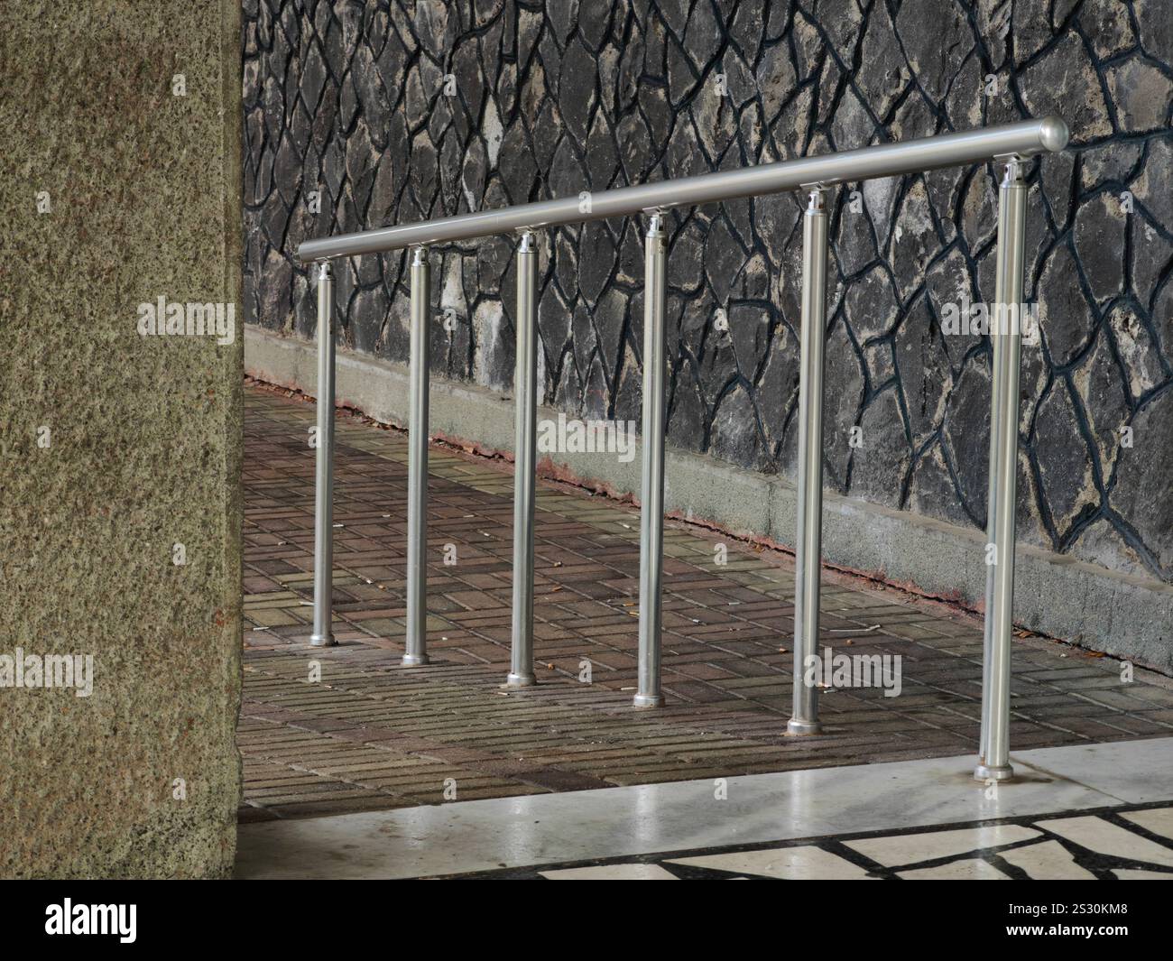 Silver Handrail Fence, around the corner. Stone wall background Stock ...