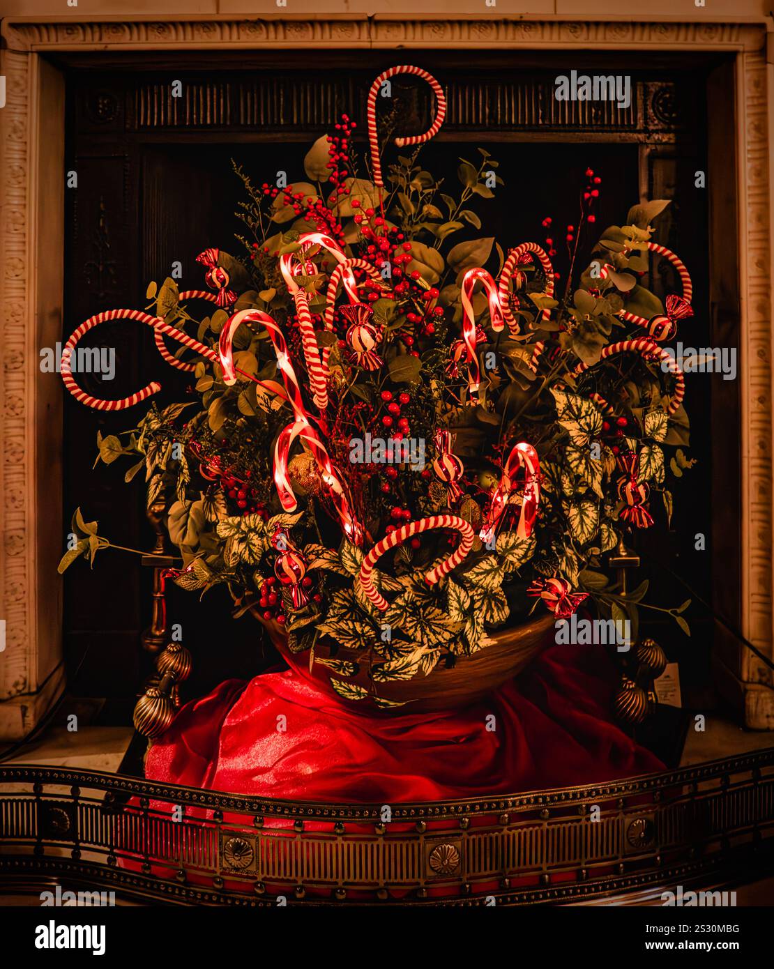 Christmas candy canes in a basket in a fireplace in an English country ...