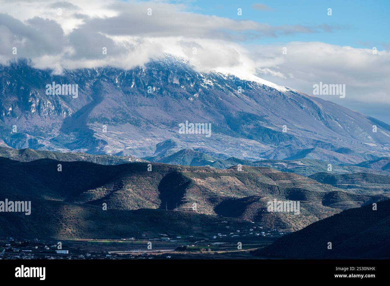 Snow topped mountains with fog and green hills around Berat, Albania ...