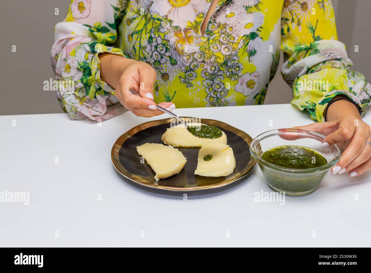 Elegant young woman serving his plate of cheese and low-fat green oil ...