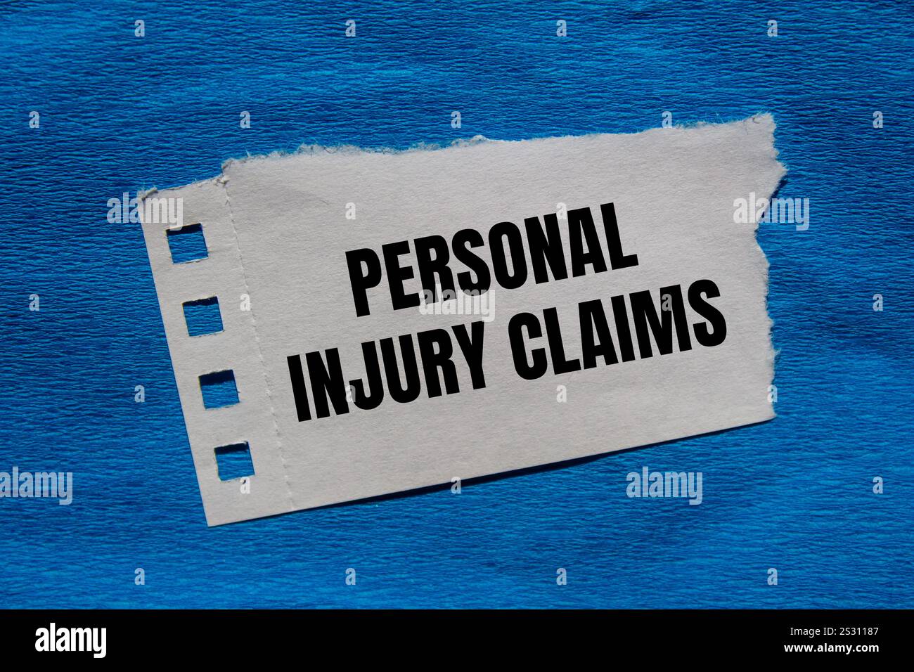 Personal injury claims message written on ripped torn paper piece with ...