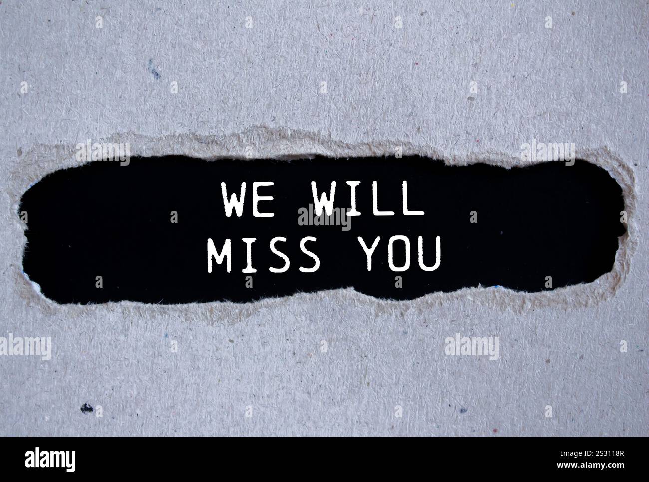 We will miss you message written on ripped torn gray paper with black background. Conceptual we ...