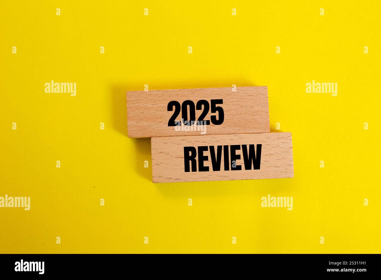 2025 review message written on wooden blocks with yellow background. Conceptual 2025 review ...