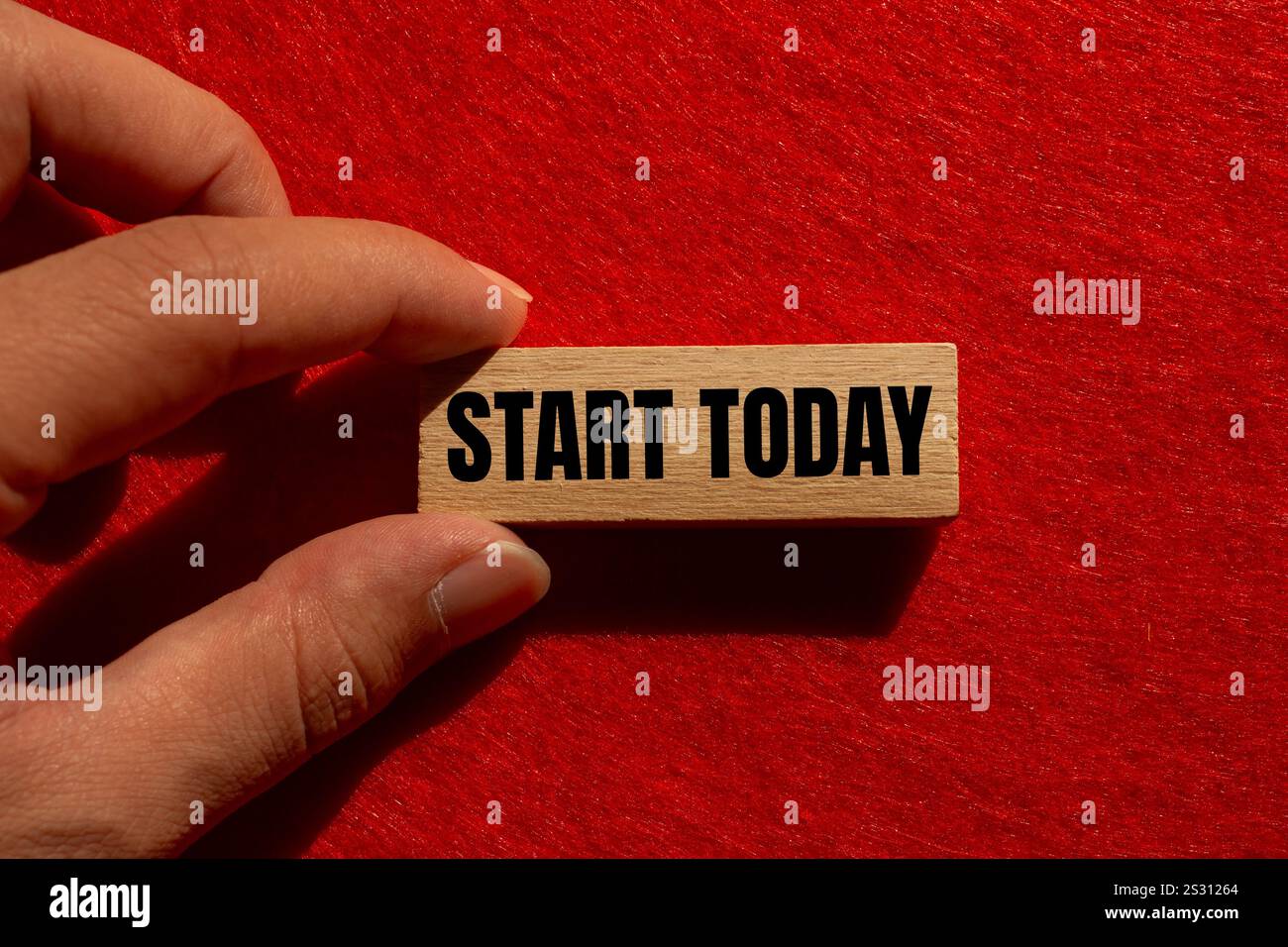 Start today message written on wooden block with red background ...