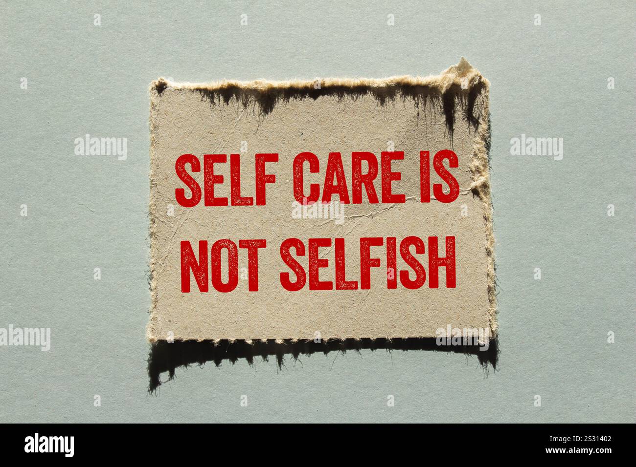 Self care is not selfish message written on ripped torn paper piece on gray background ...