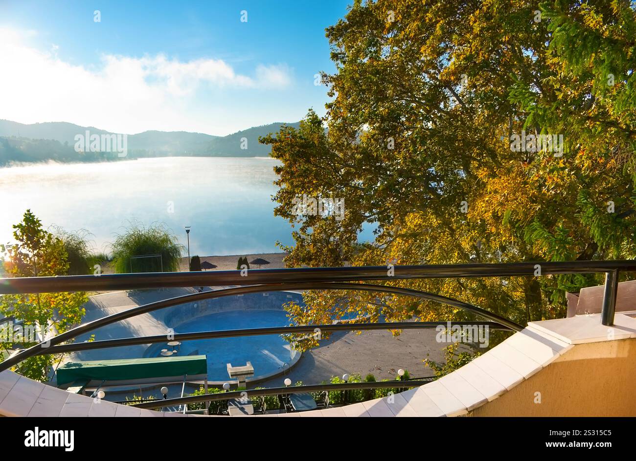 The hotel terrace opens the view of the small pool, lush green park and ...