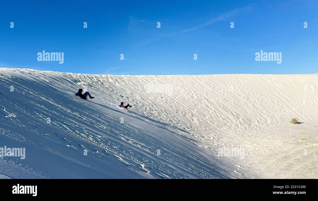 Boys sledding down a hill at White Sands National Park in New Mexico ...
