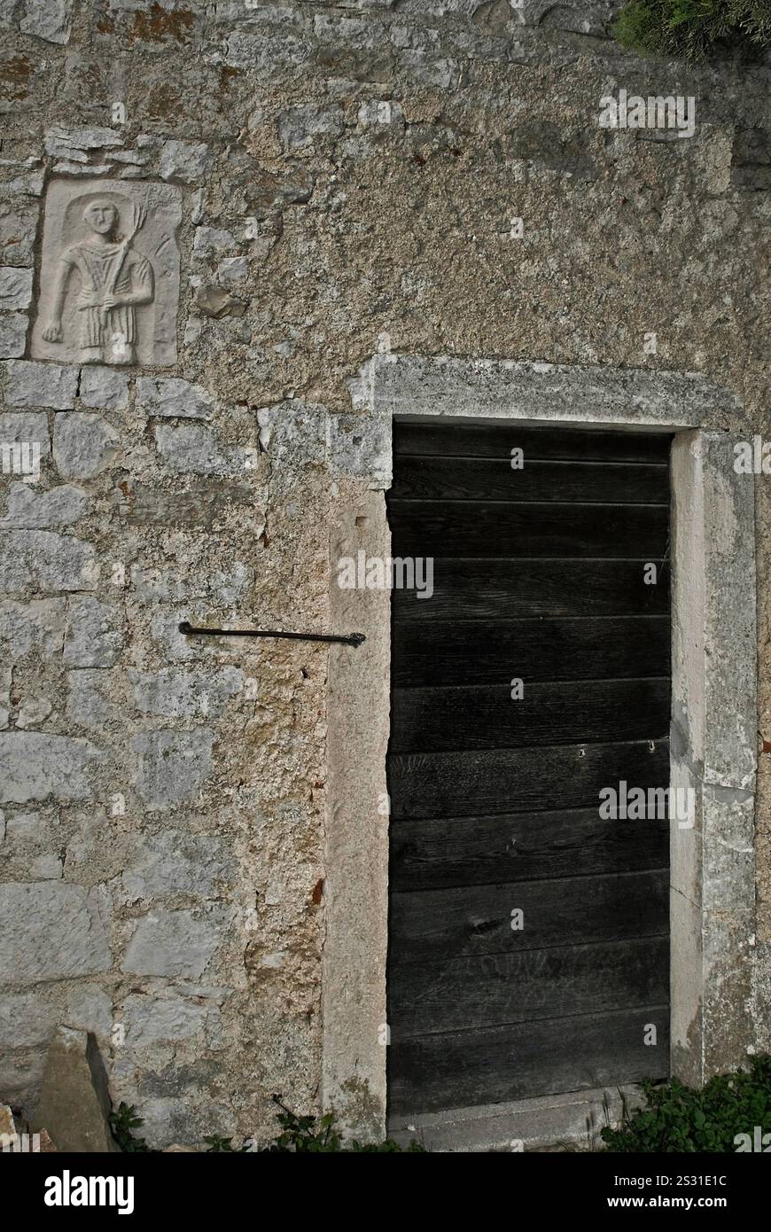 A tunic-wearing man holds a branch with three twigs or prongs in the ...