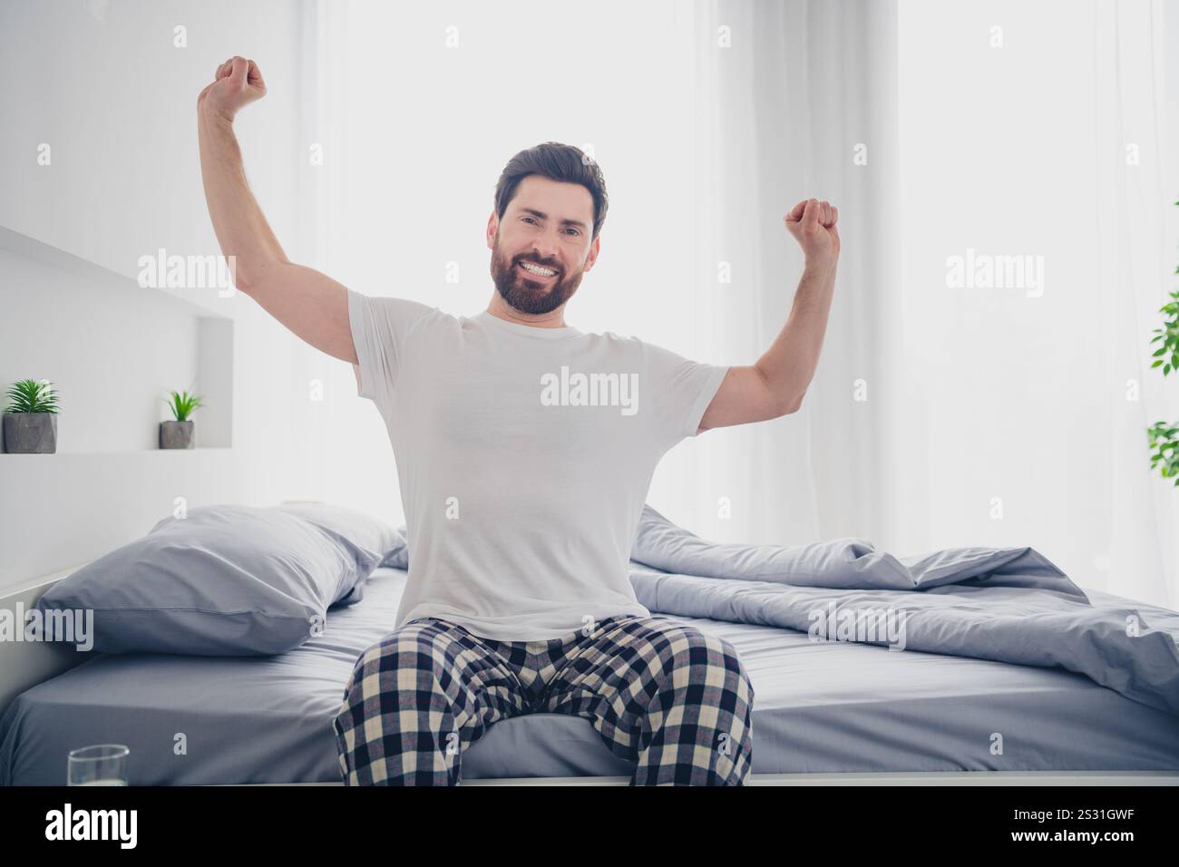 Photo of funky happy mature guy sleepwear pajama sitting bed stretching ...