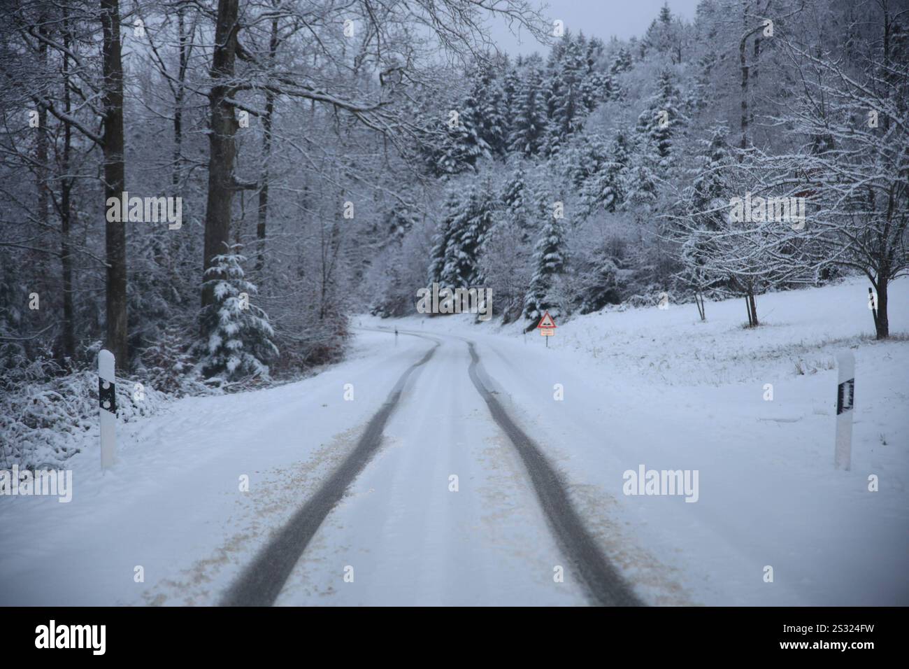 Schneebedeckte Straßen, Schnee liegt auf den Straßen und Bäumen rund um ...