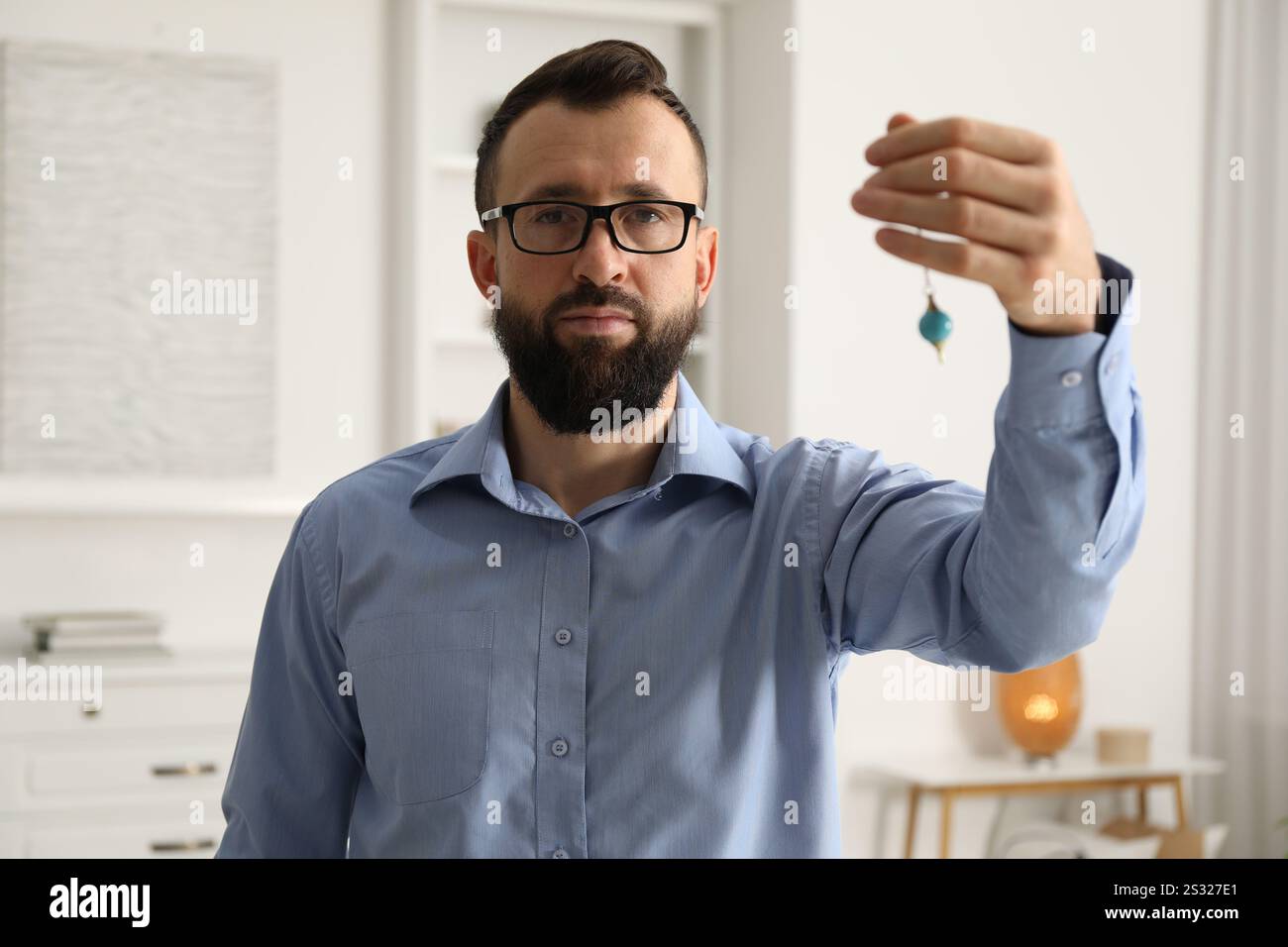 Hypnosis session. Man in glasses swinging pendulum indoors Stock Photo ...