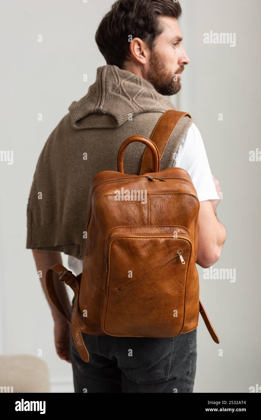 A Stylish and Man standing with a yellow brown backpack in a ...