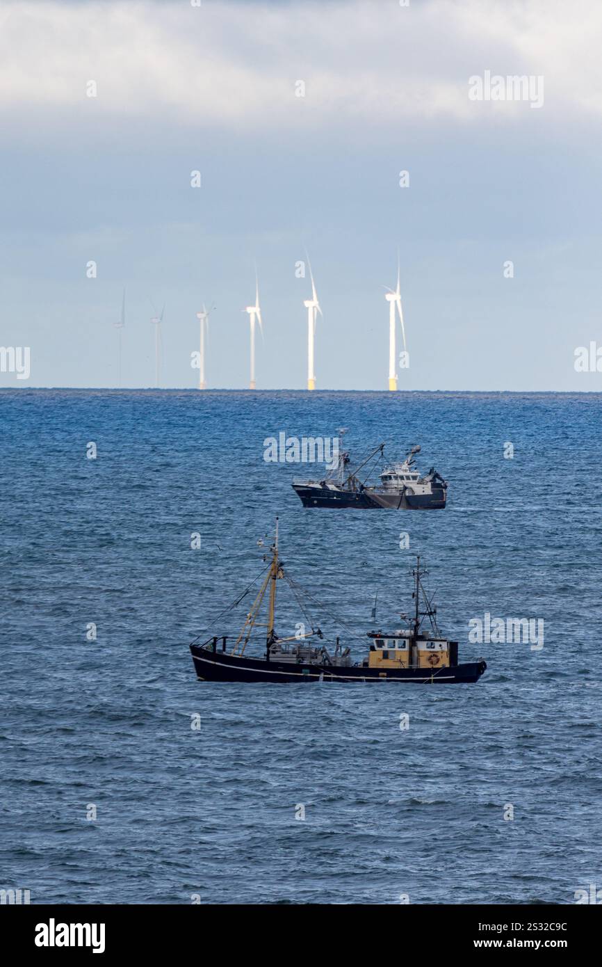 Two fishing vessels in front of an offshore wind park in the North sea ...
