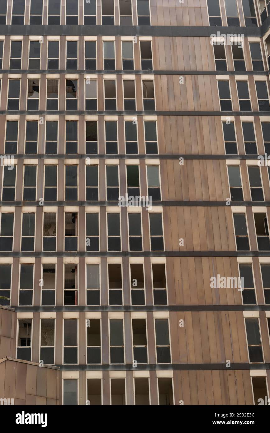 A pattern of windows of an abandoned high rise building, a dated ...