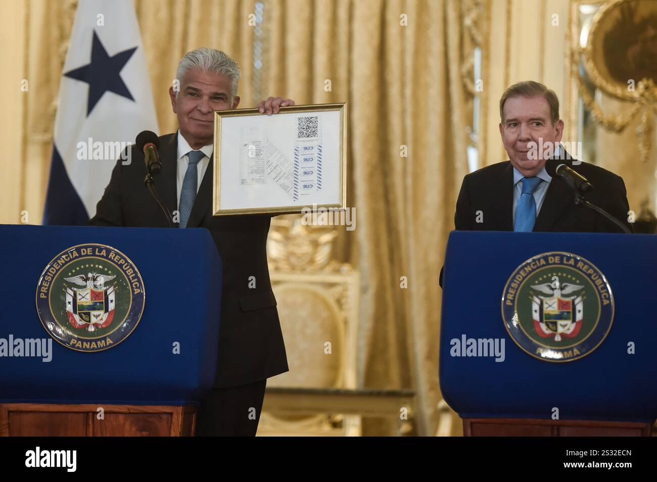 Panamanian President Jose Raul Mulino, left, holds up a copy of ...