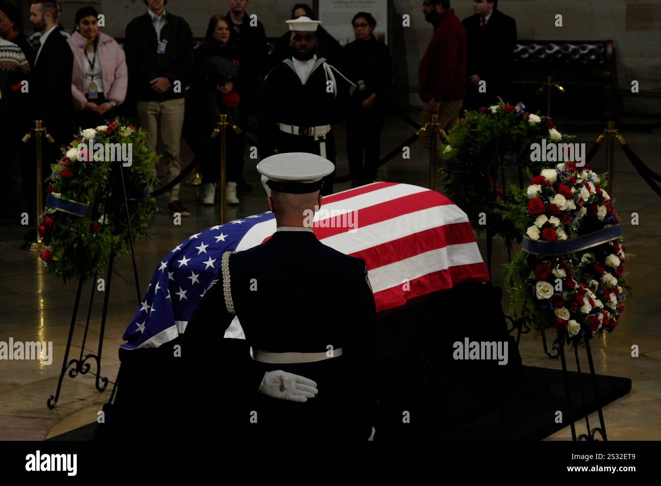 Honor guards pay their respects as the flag-draped casket of former ...