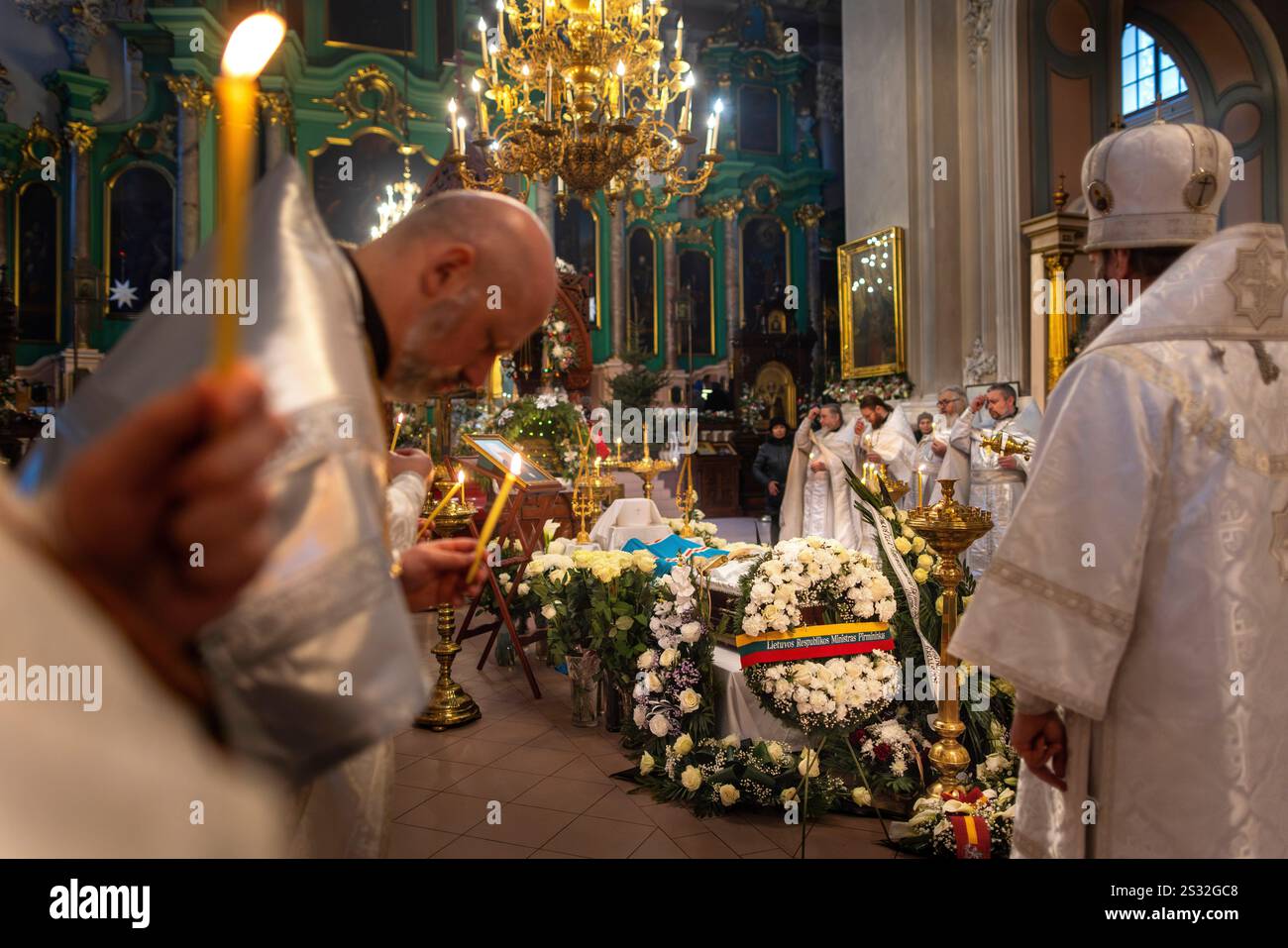 Orthodox priests hold candles and pray during the funeral ceremony of ...