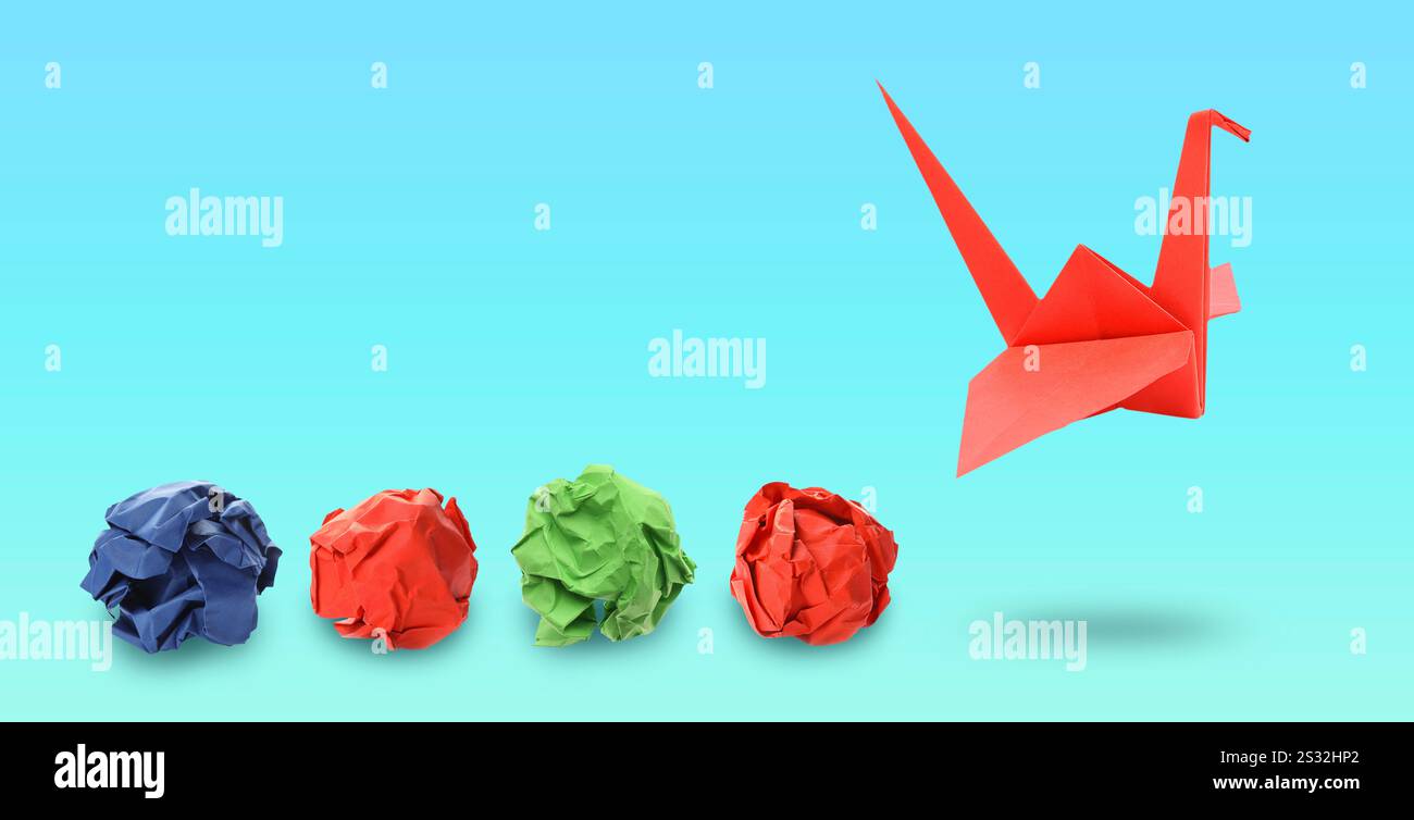 Red origami crane and crumpled paper balls on blue gradient background ...